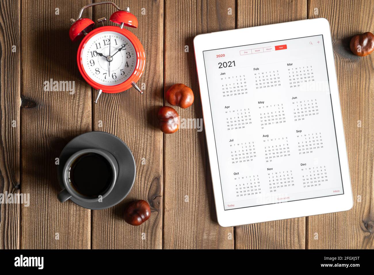a tablet with an open calendar for 2021 year, a cup of coffee ...