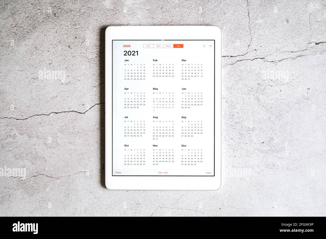 a tablet with an open calendar for 2021 year on a gray concrete ...