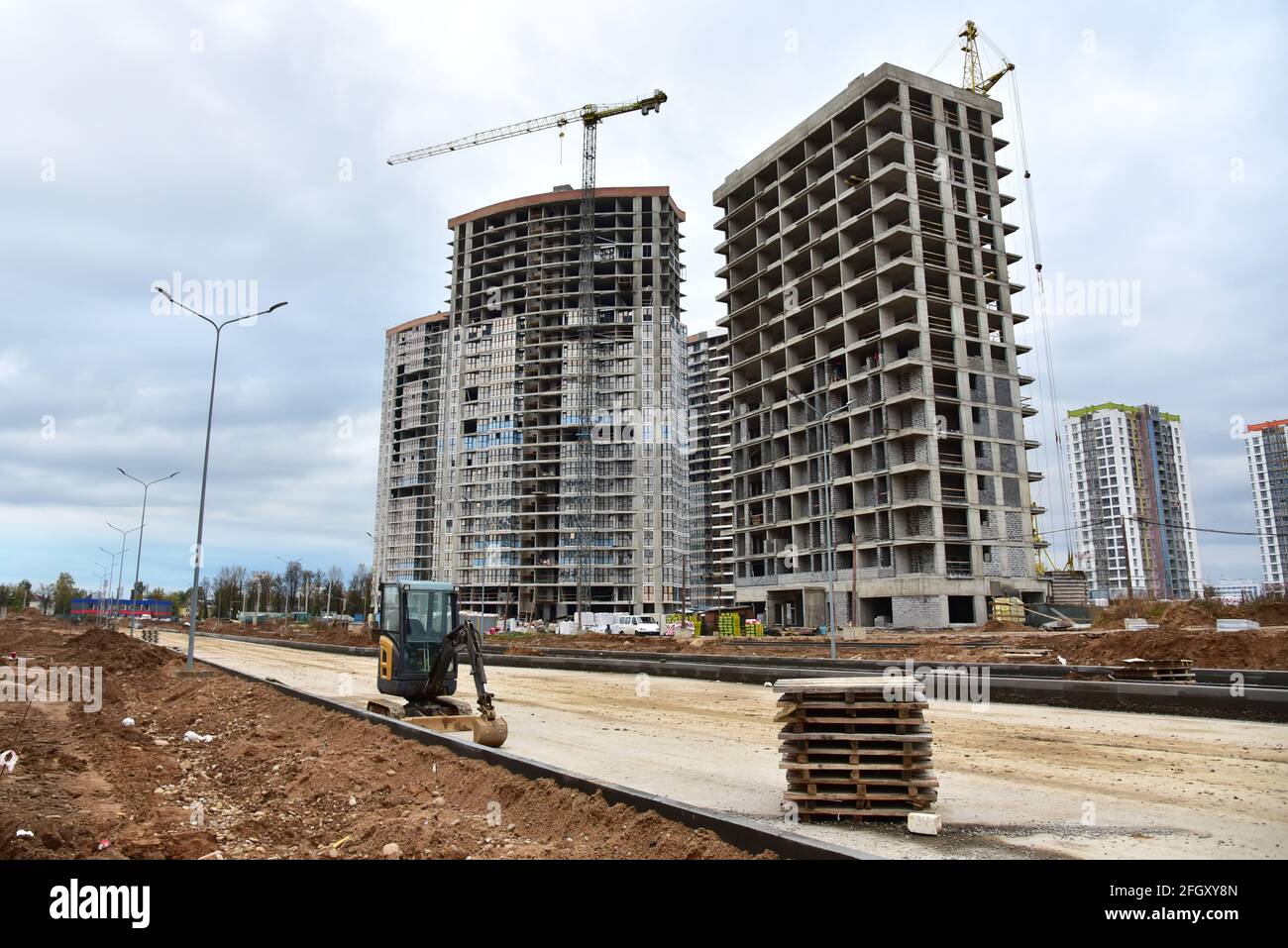 View of the larger construction site. Tower cranes are building multi ...