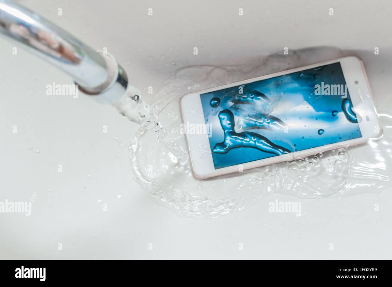 Smartphone dropped into the sink under the water. Concept mobile phone ...
