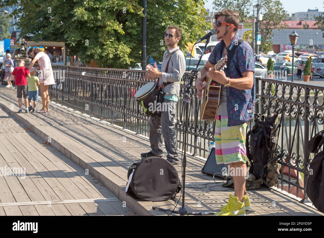 Street band of two guys with drum and guitar gives a concert on Honey ...