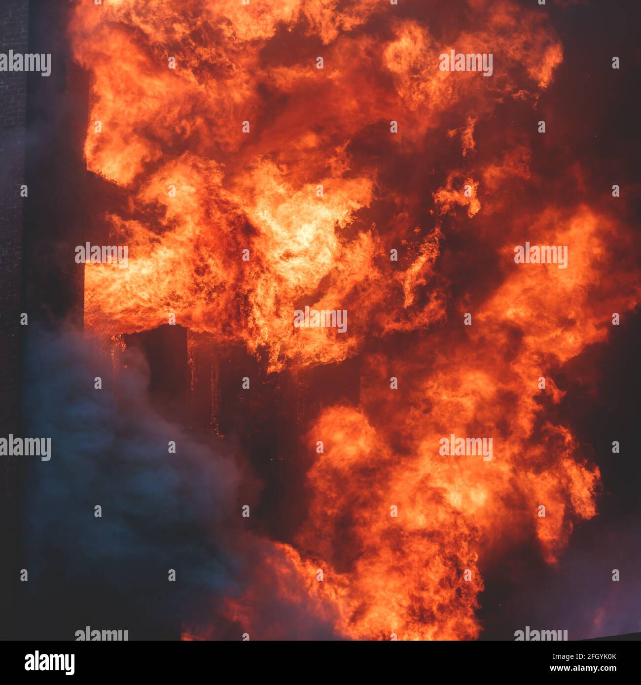 Massive large blaze fire in the city, brick factory building on fire ...