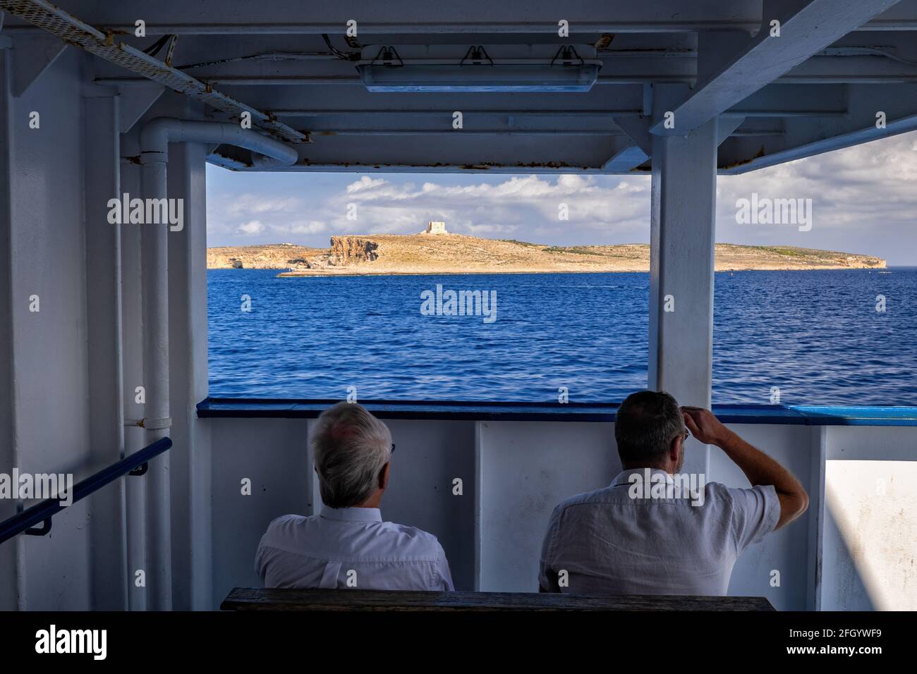Passengers enjoy the view to Comino Island from deck of Gozo Channel ...
