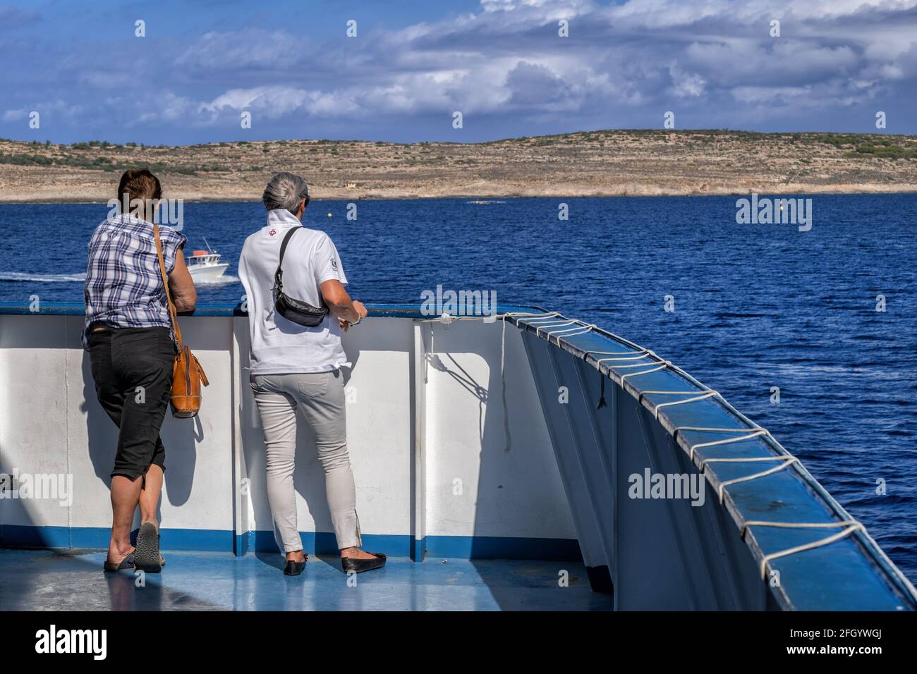 Mature women enjoy the view to Comino Island from deck of Gozo Channel ...