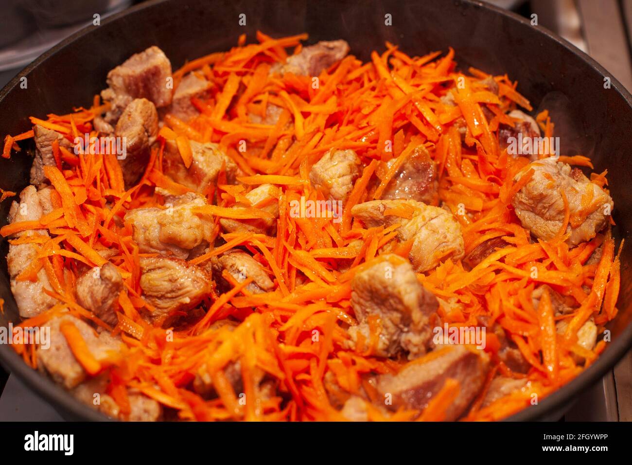 meat fried with carrots in a frying pan. High quality photo Stock Photo ...