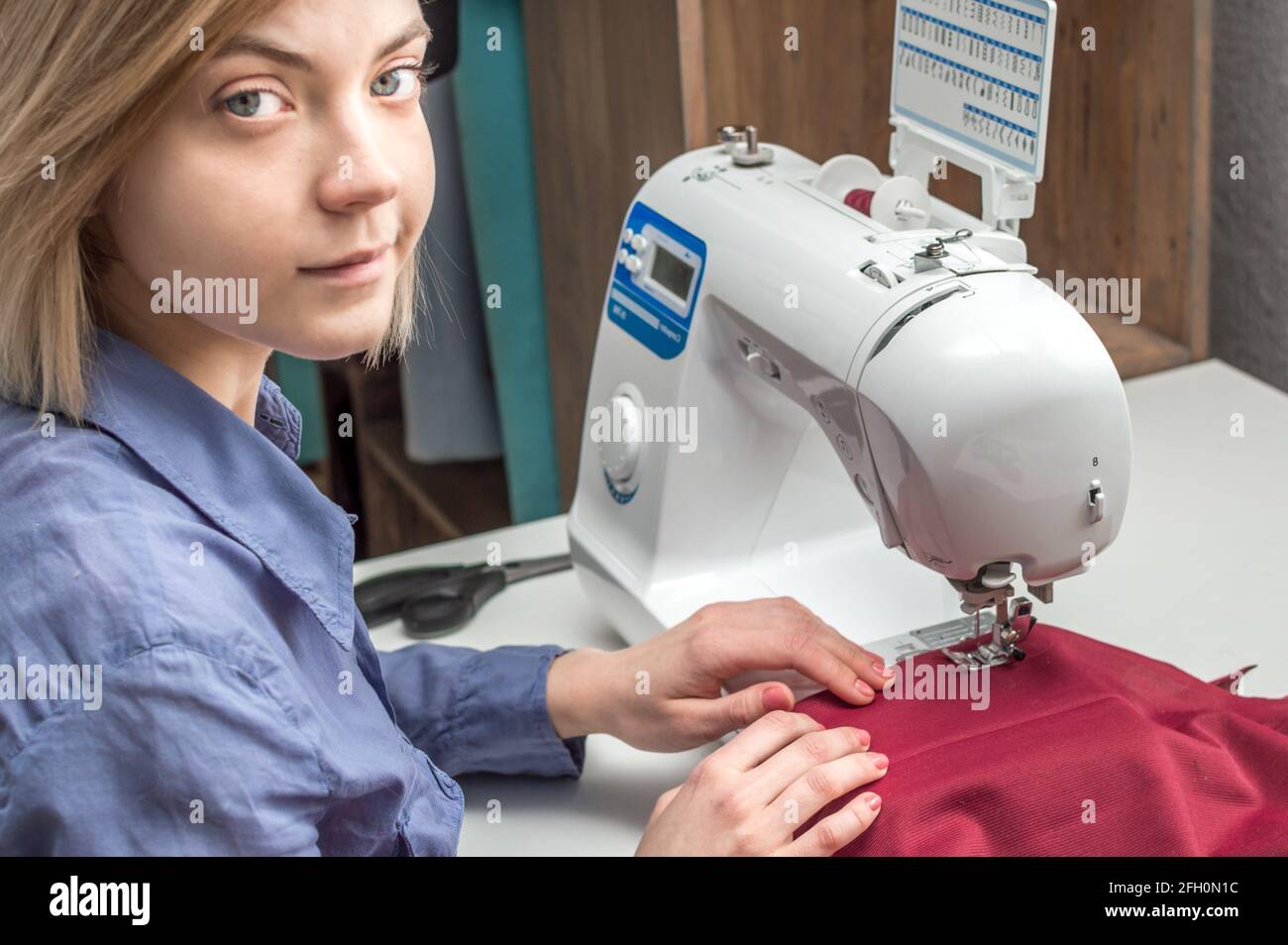 Seamstress sews clothes on a sewing machine. Concept sewing workshop ...