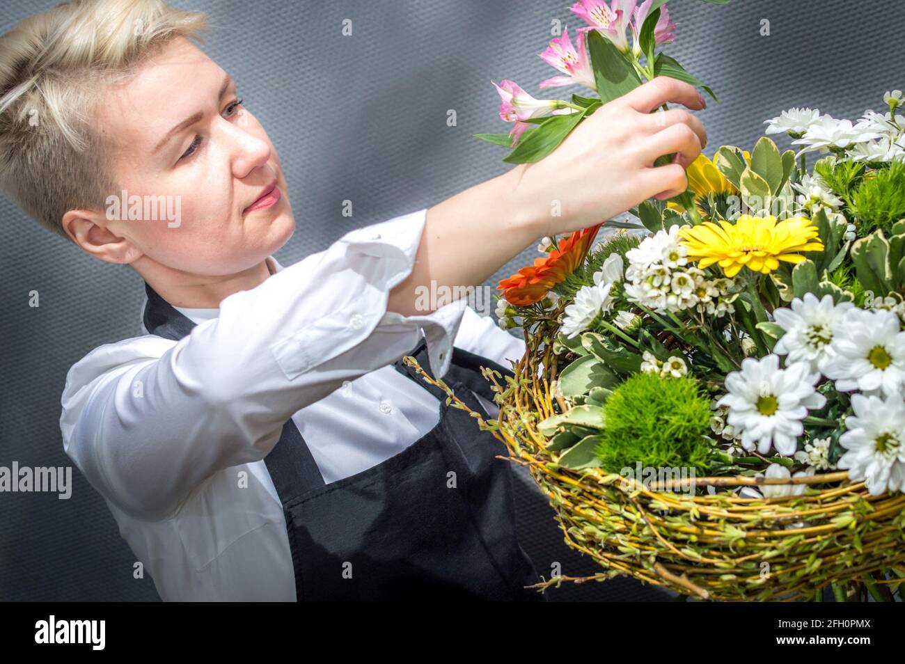young woman collects flowers in a bouquet. Close-up. Concept flower ...