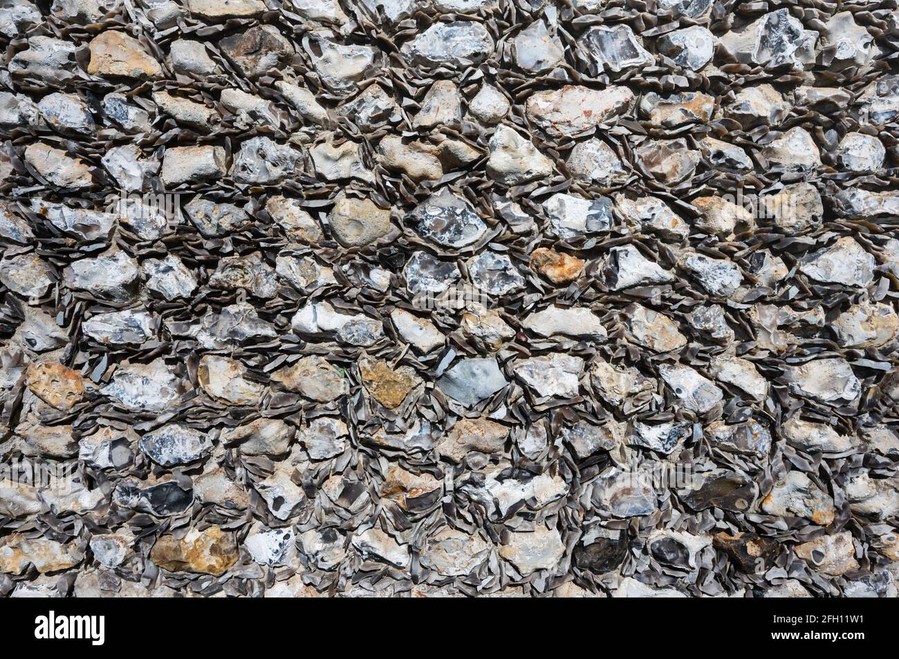 Front flat view of a flint wall on an old church building. For use as a ...