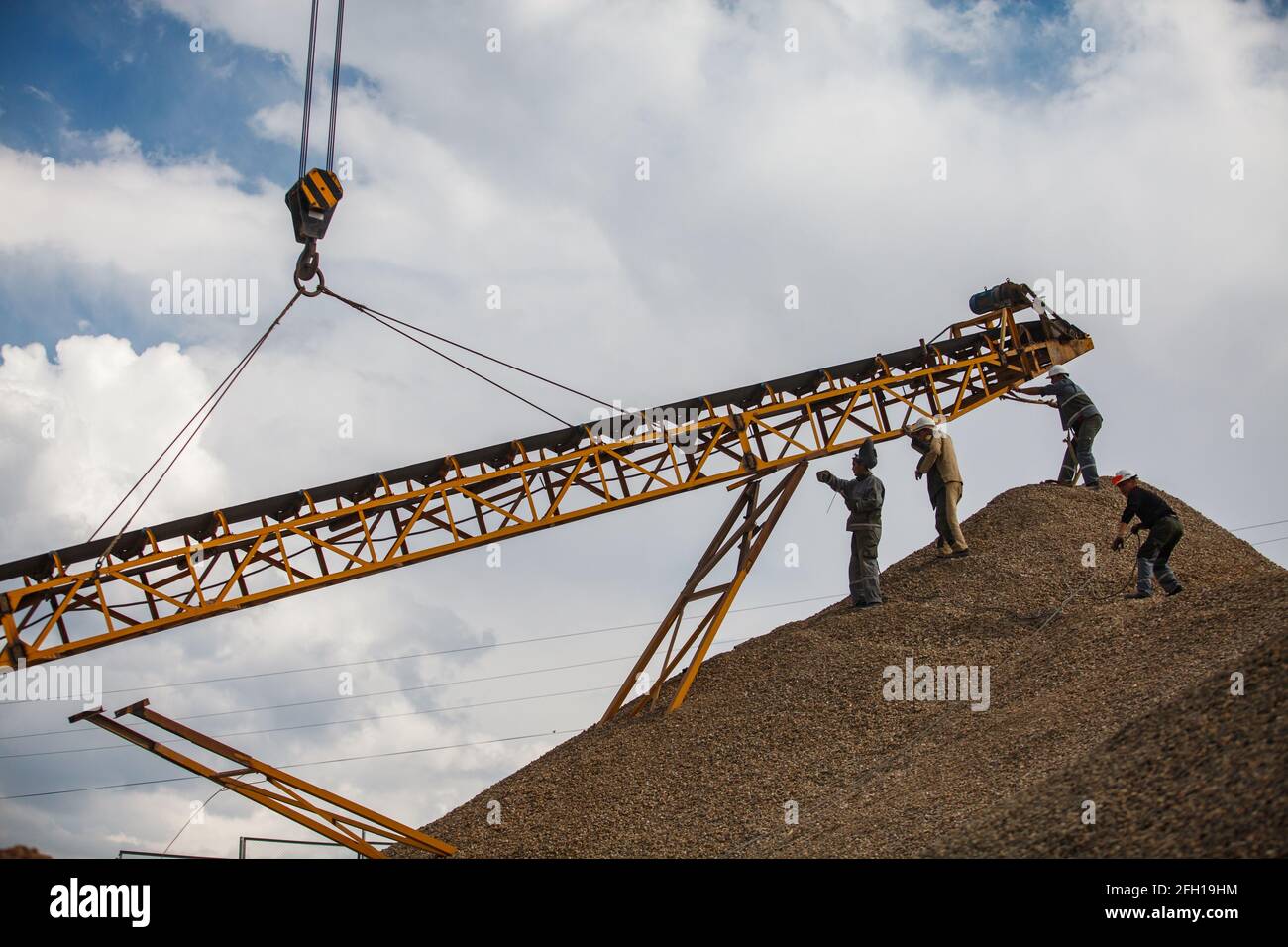 Mining and processing plant. Workers assembling rock crushing machine ...