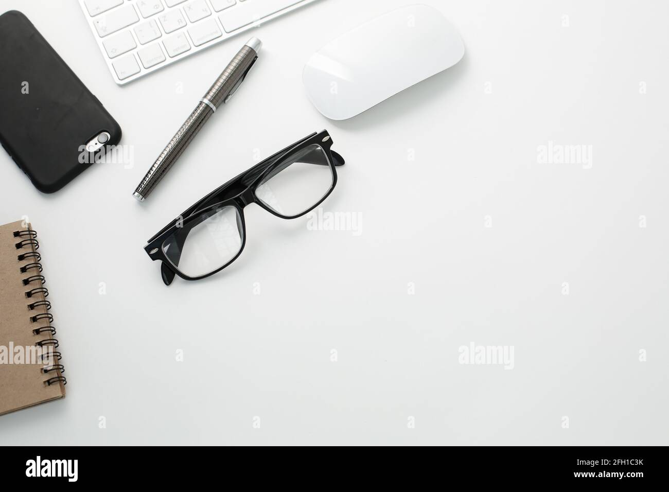 Office workplace with keyboard, notepad, glasses telephone and pen on ...