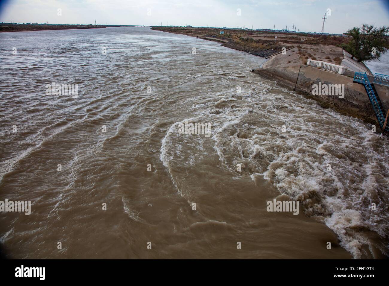 Dam of Shardara river. Concrete walls. turbulent river yellow water ...