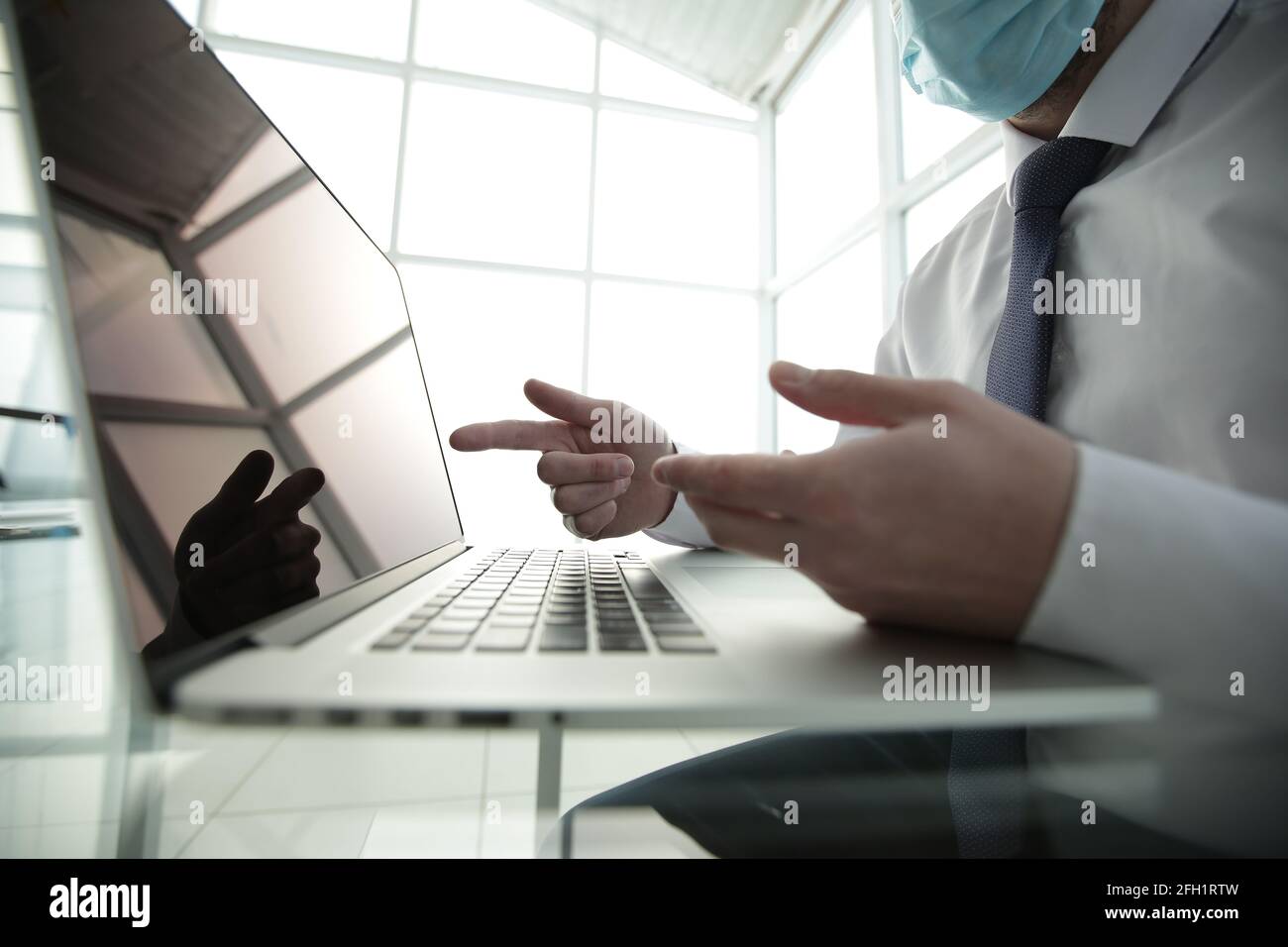 Concentrated young male professional wearing breath protective mask ...