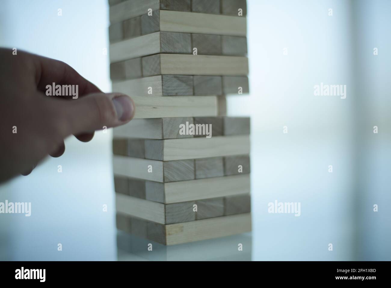 Hand, board game - wooden bars on a glass table Stock Photo - Alamy