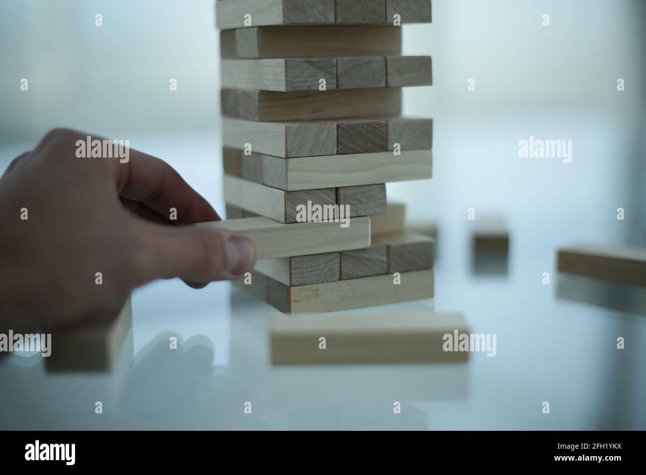 Hand, board game - wooden bars on a glass table Stock Photo - Alamy