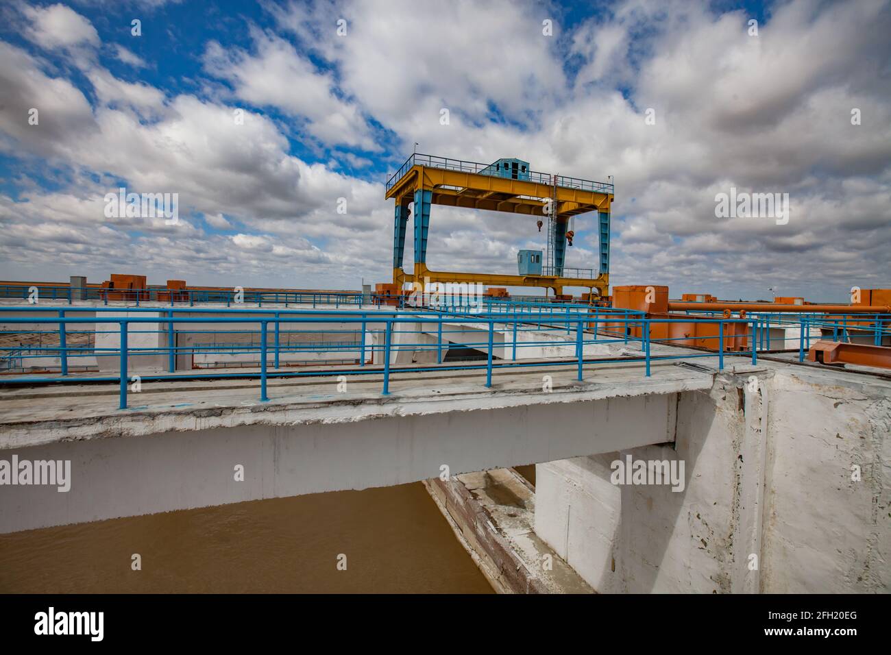 Shardara river dam and bridge over yellow water. Blue and yellow ...