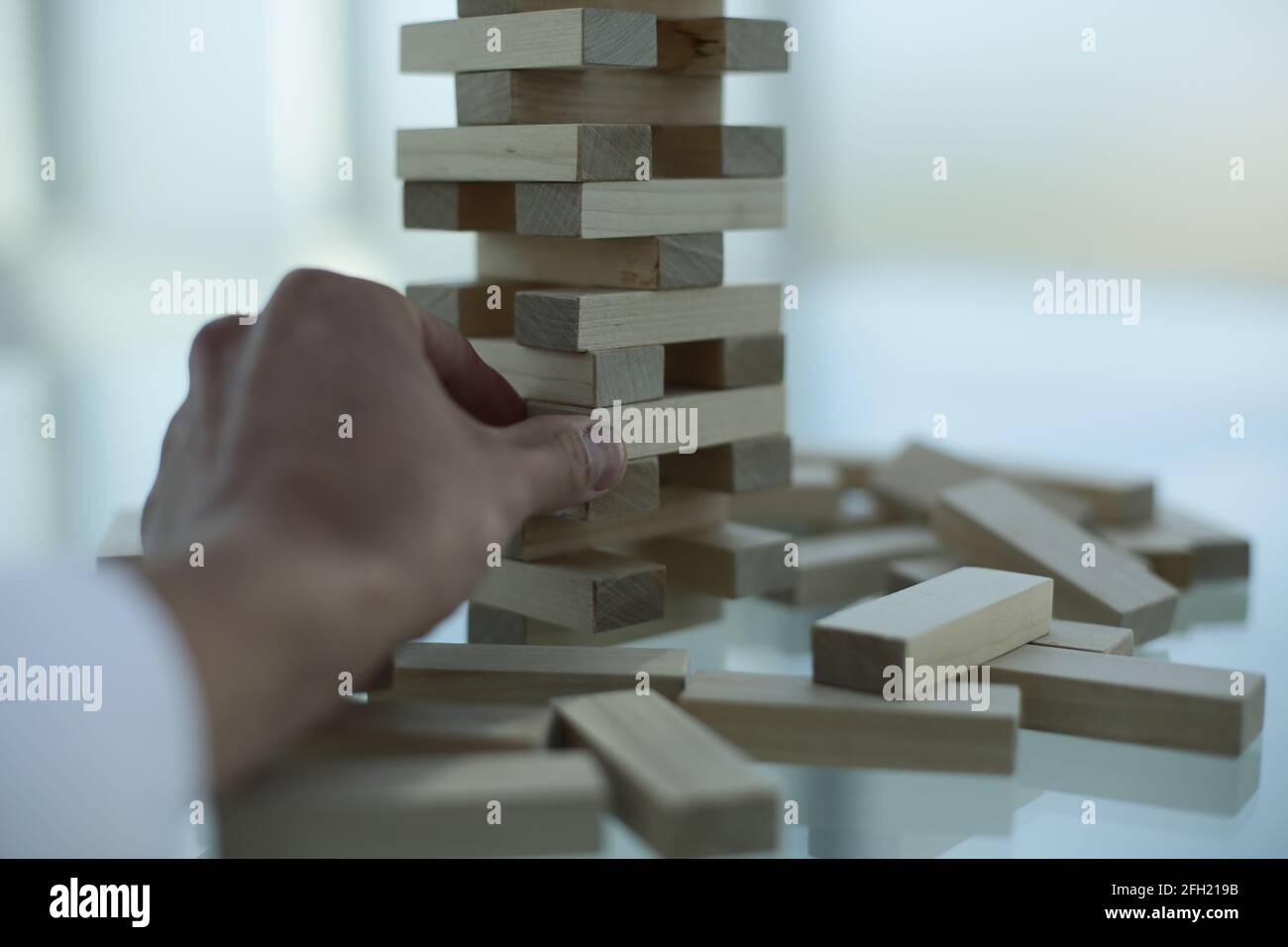 Hand, board game - wooden bars on a glass table Stock Photo - Alamy