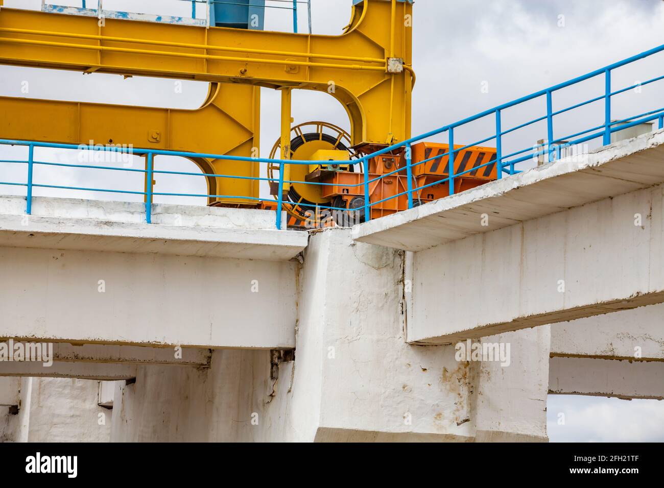 Close up photo of gentry crane's wheel and winch with steel rope. Dam ...