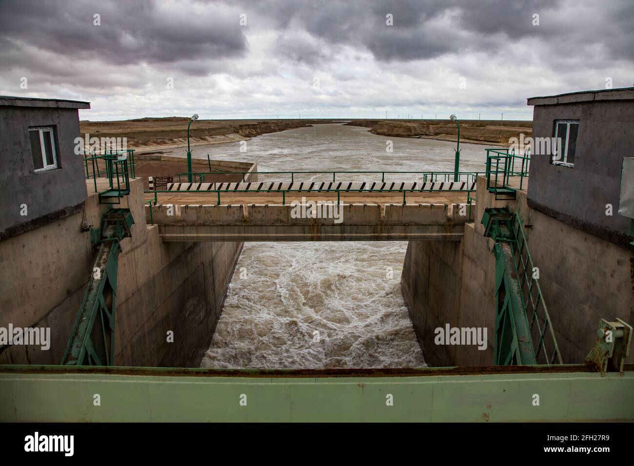 Aklak dam controls Shardara river's water level. Green metal shutter on ...