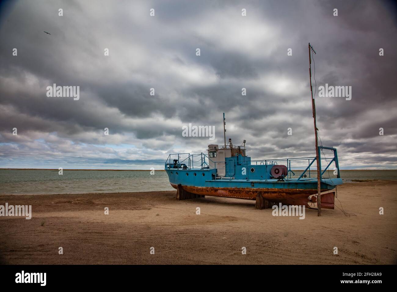 Small Aral sea Kok-aral sand dam. Fishing boat on the beach. Aral on ...