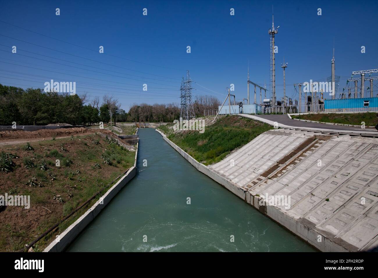 Hydroelectric power plant. Calm water in channel after dam and electric ...