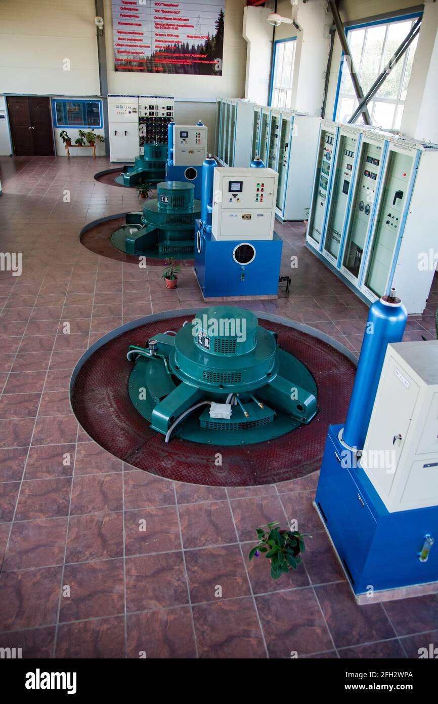 Hydroelectric power plant machine room.Three green electric generators ...