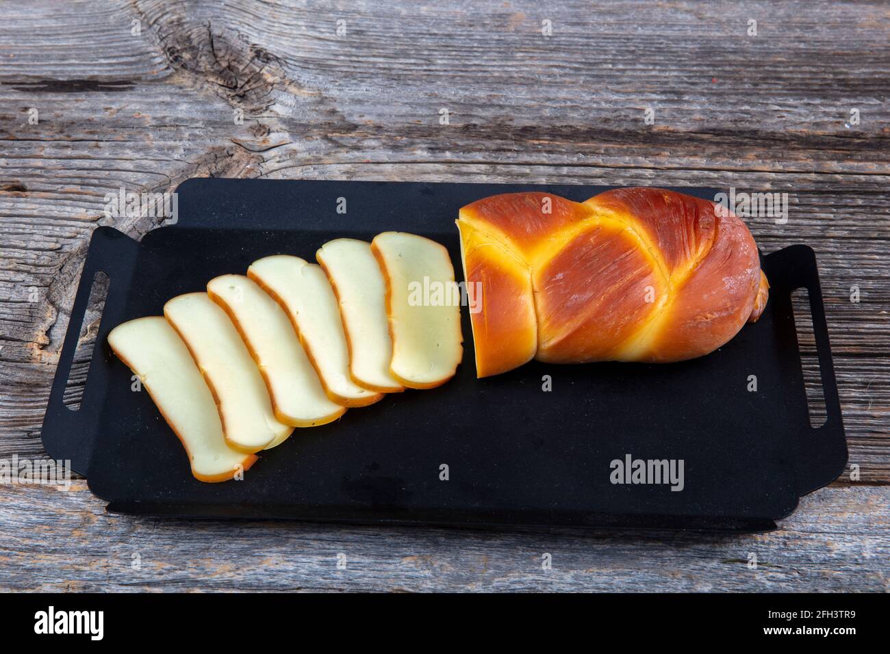 Braided Smoked Cheese. Smoked cheese and cheese on dark wood table ...