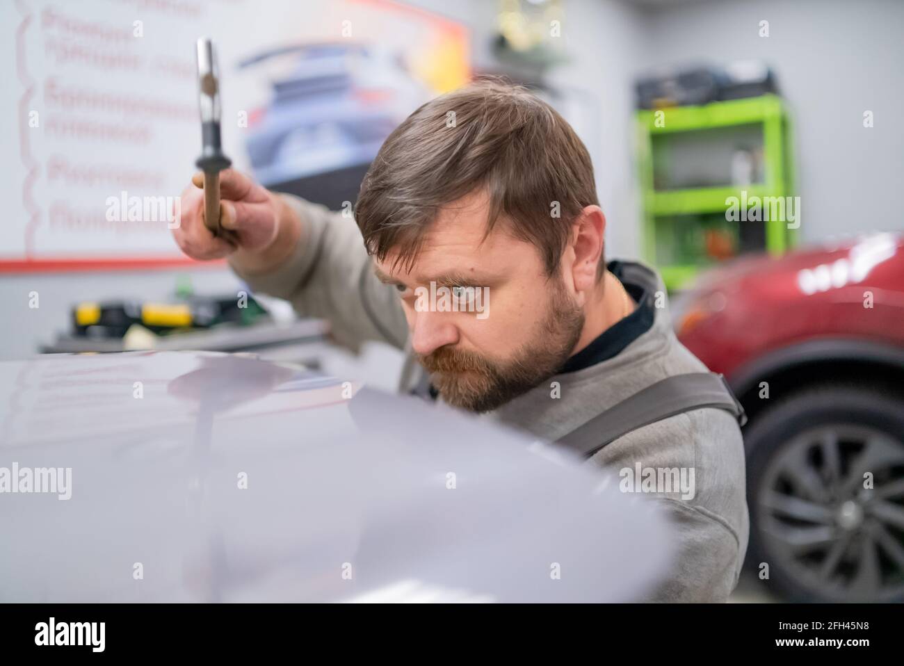 Close shot of dent removing without paint, using rubber hammer Stock ...