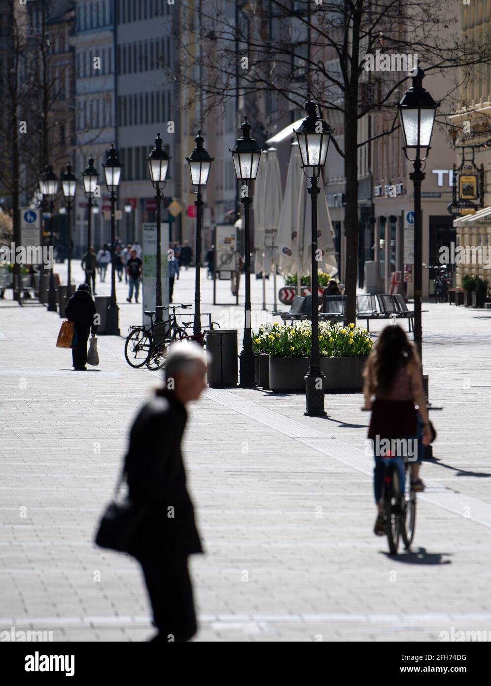 Munich, Germany. 25th Apr, 2021. Passers-by walk through the pedestrian ...