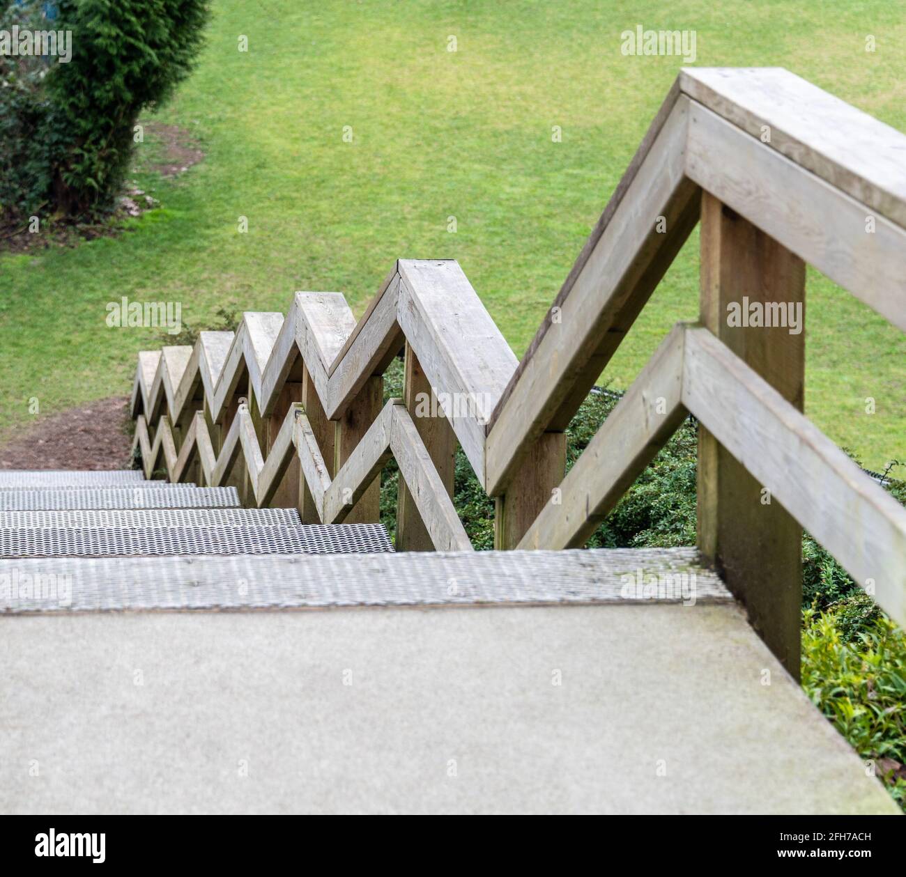 Zig-zag railings of wooden stairway on green grass background Stock ...
