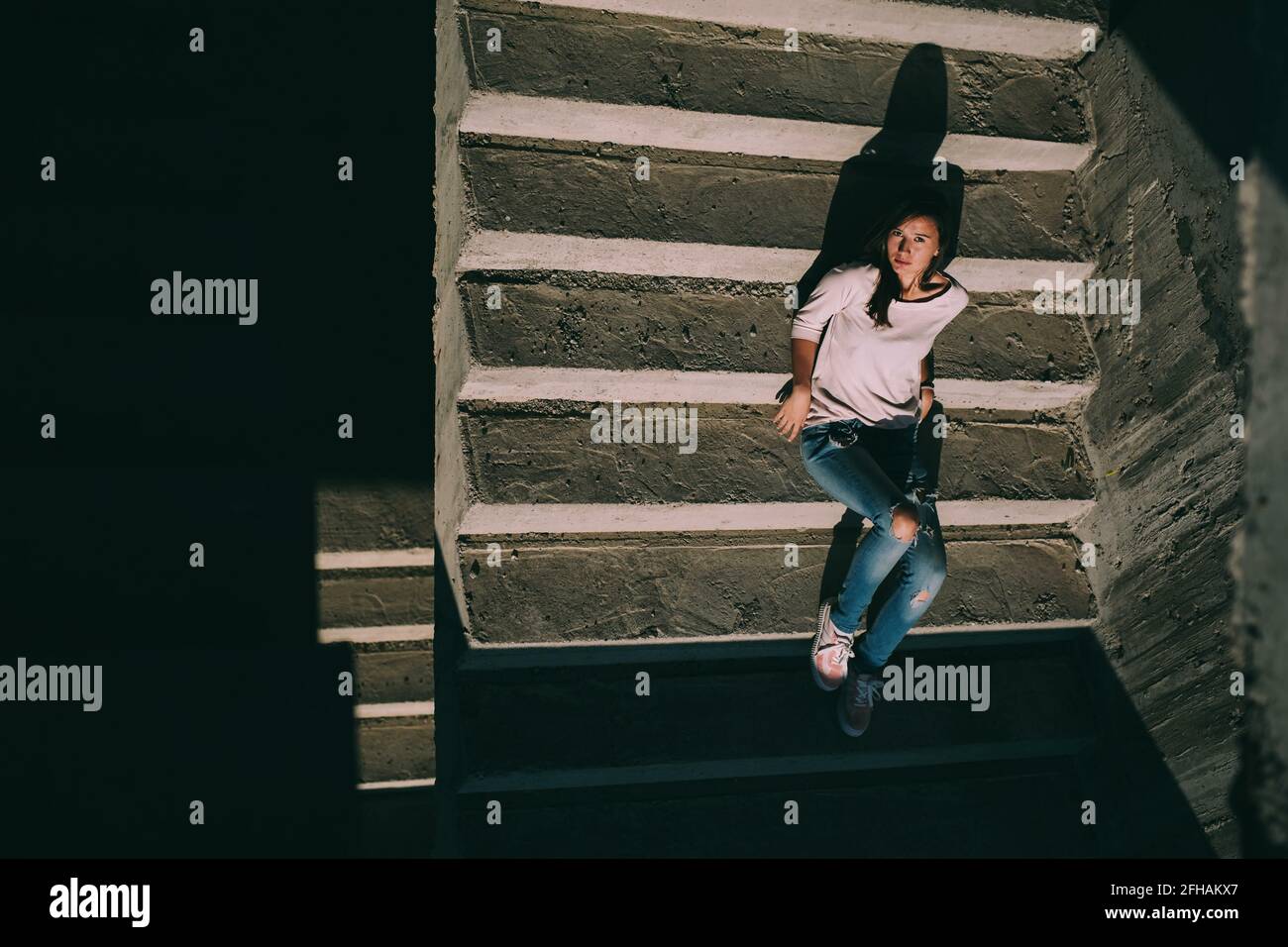 An overhead shot of a Caucasian female sitting on outdoor stairs Stock ...
