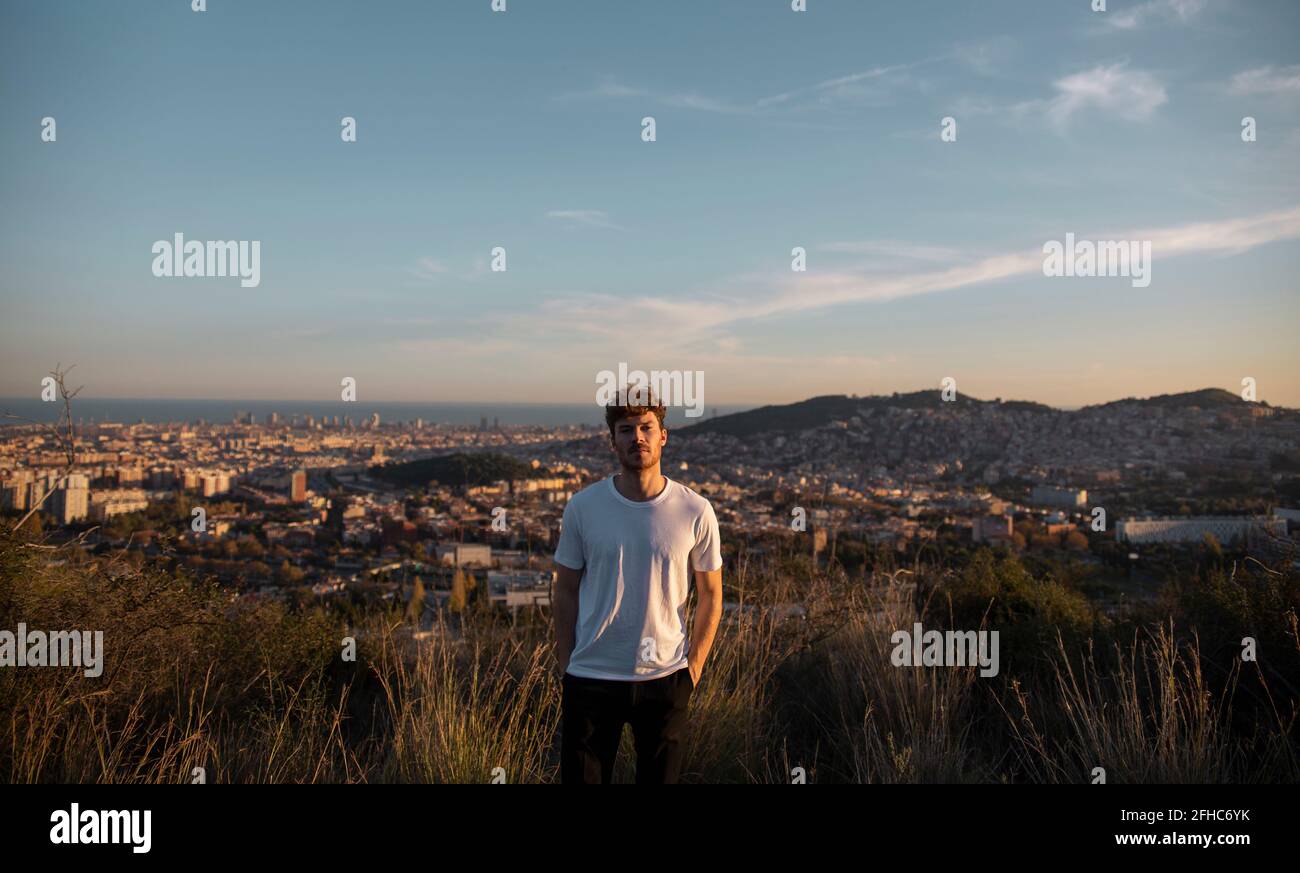 Female owner with obedient Labradoodle dog sitting on rock in mountains ...