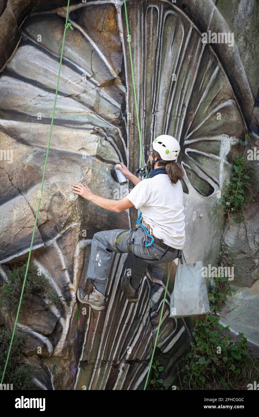 Back view full body of painter with spray paint making graffiti hanging ...