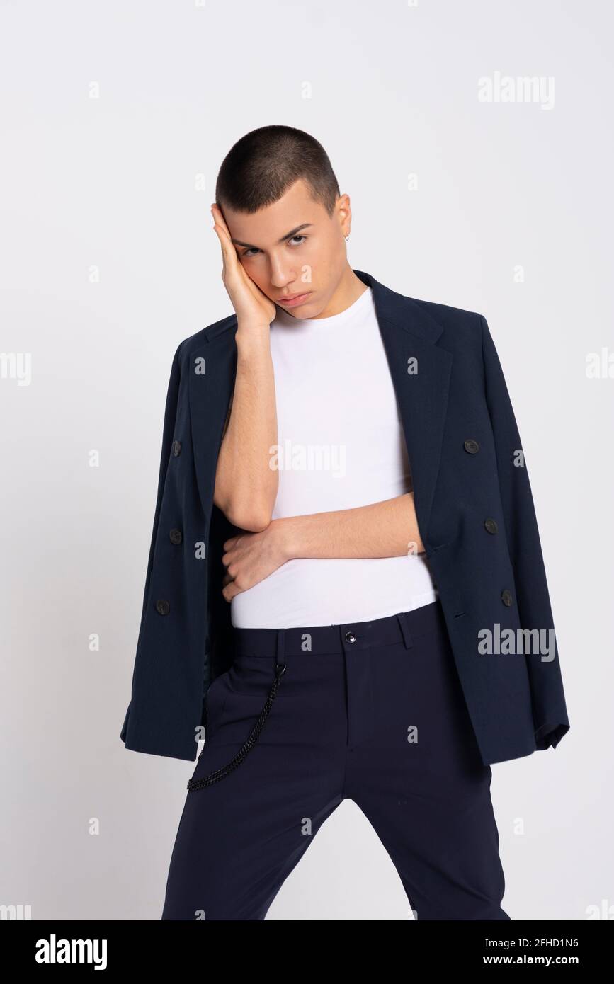 Serious male model in fashionable suit standing on white background in ...