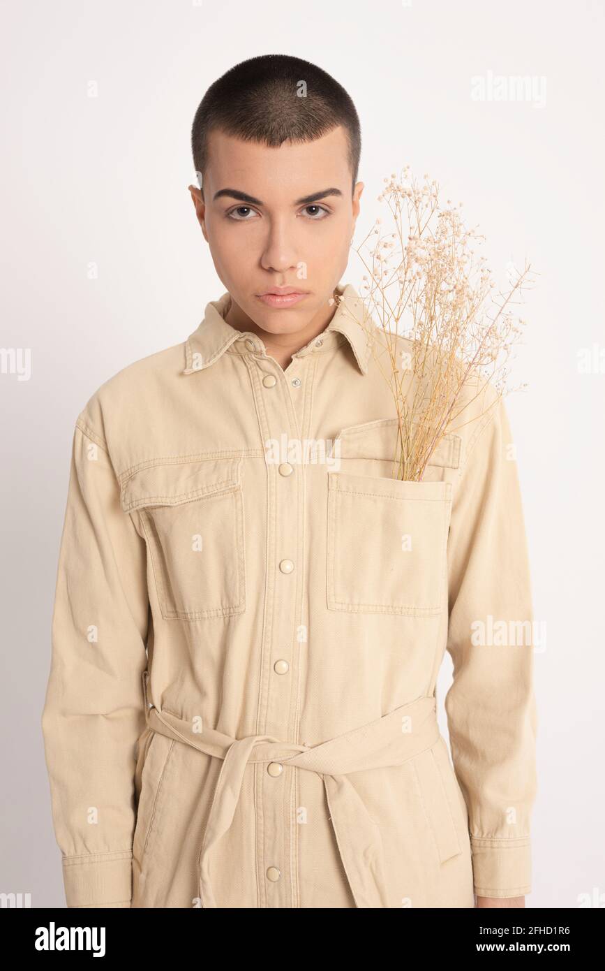 Androgynous male model in trendy shirt and with bunch of dried plants ...
