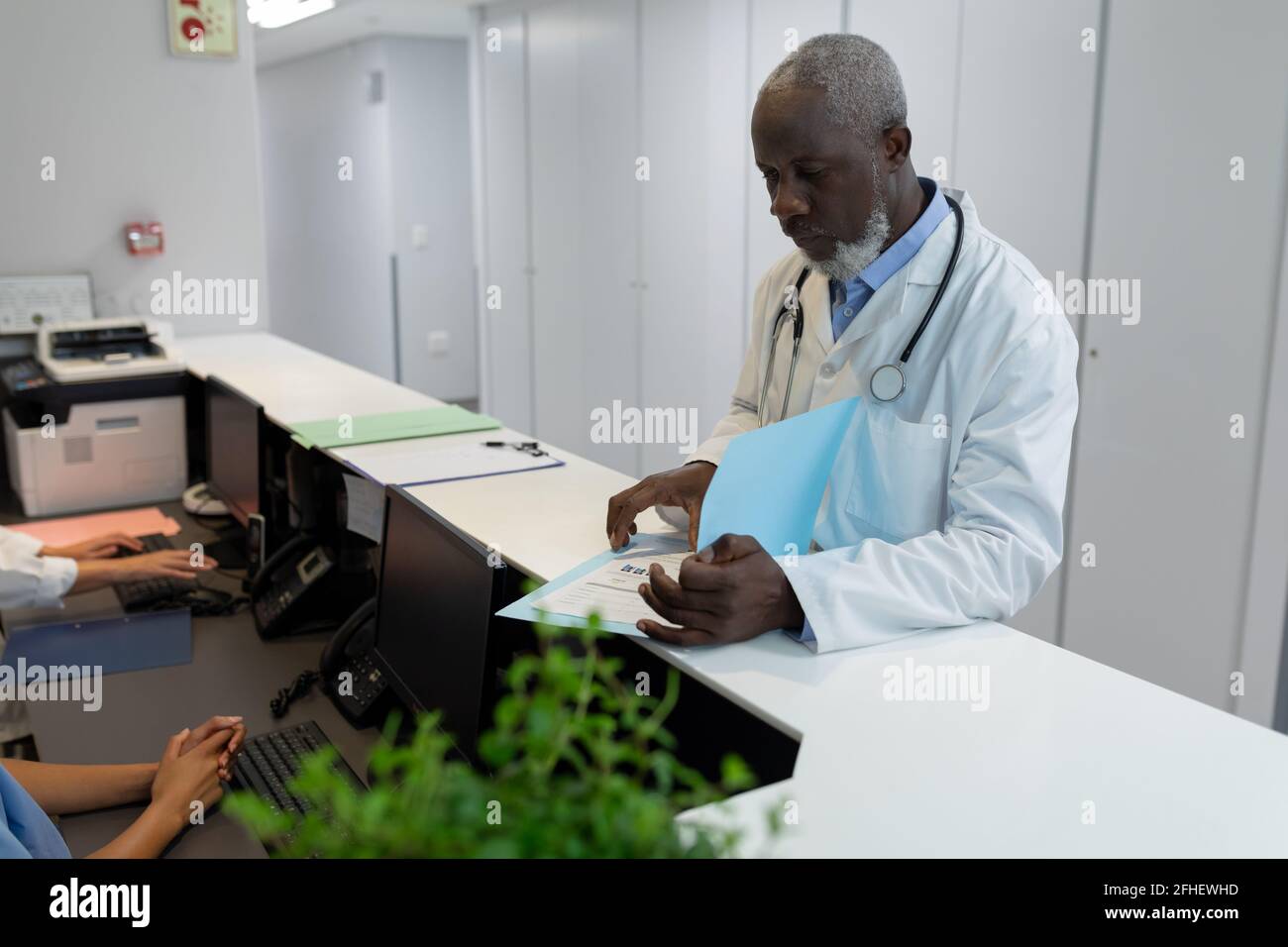 African american doctor standing in hospital corridor smiling to camera ...