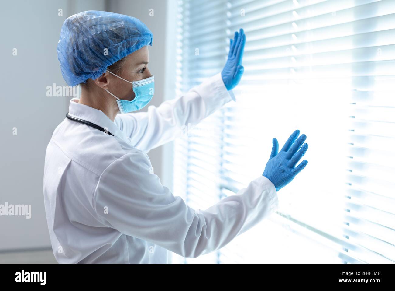 Caucasian female doctor wearing face mask using virtual interactive ...