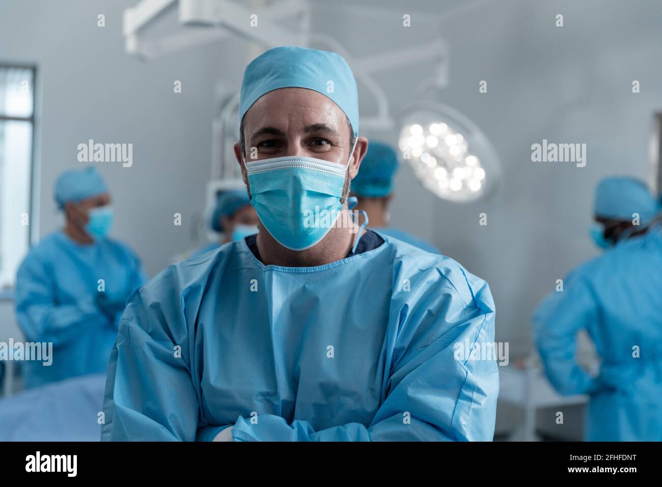 Portrait of caucasian male surgeon wearing face mask and protective ...