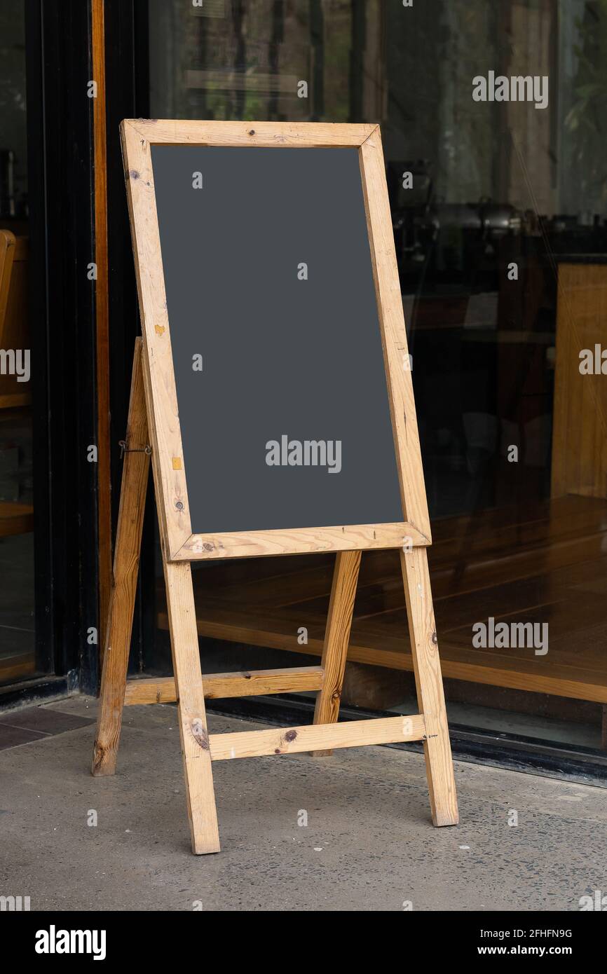 Old blackboard stand in front of restaurant or cafe, empty for ...