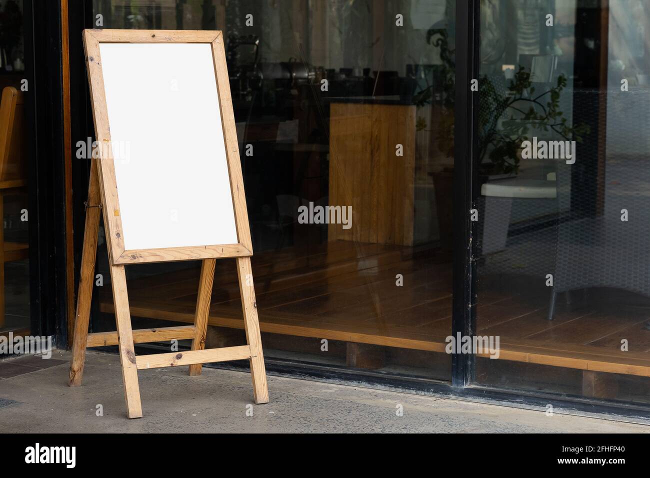 Old whiteboard stand in front of restaurant or cafe, empty for ...