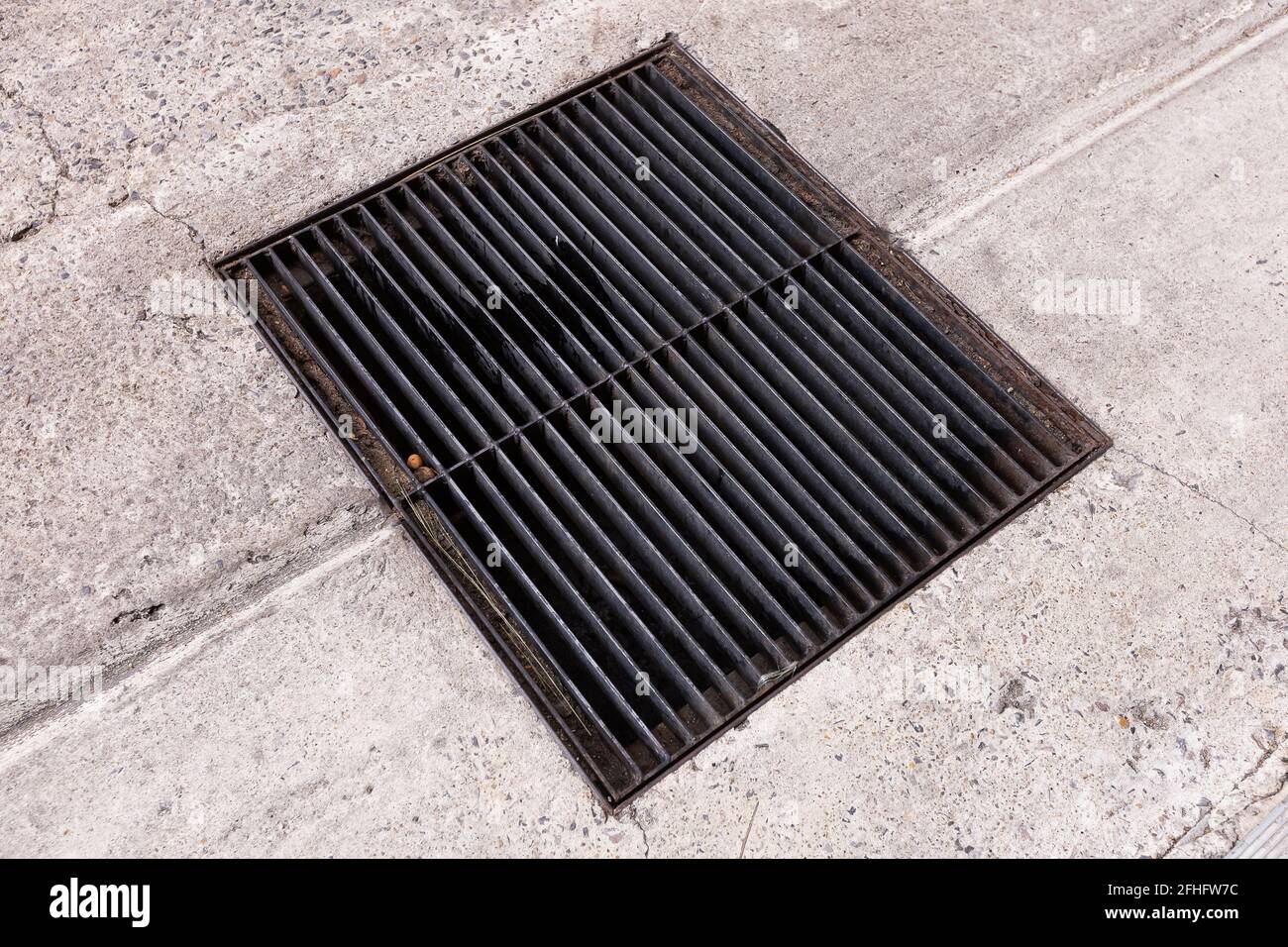 Closeup grunge old and rusty steel drainage grating on concrete road ...