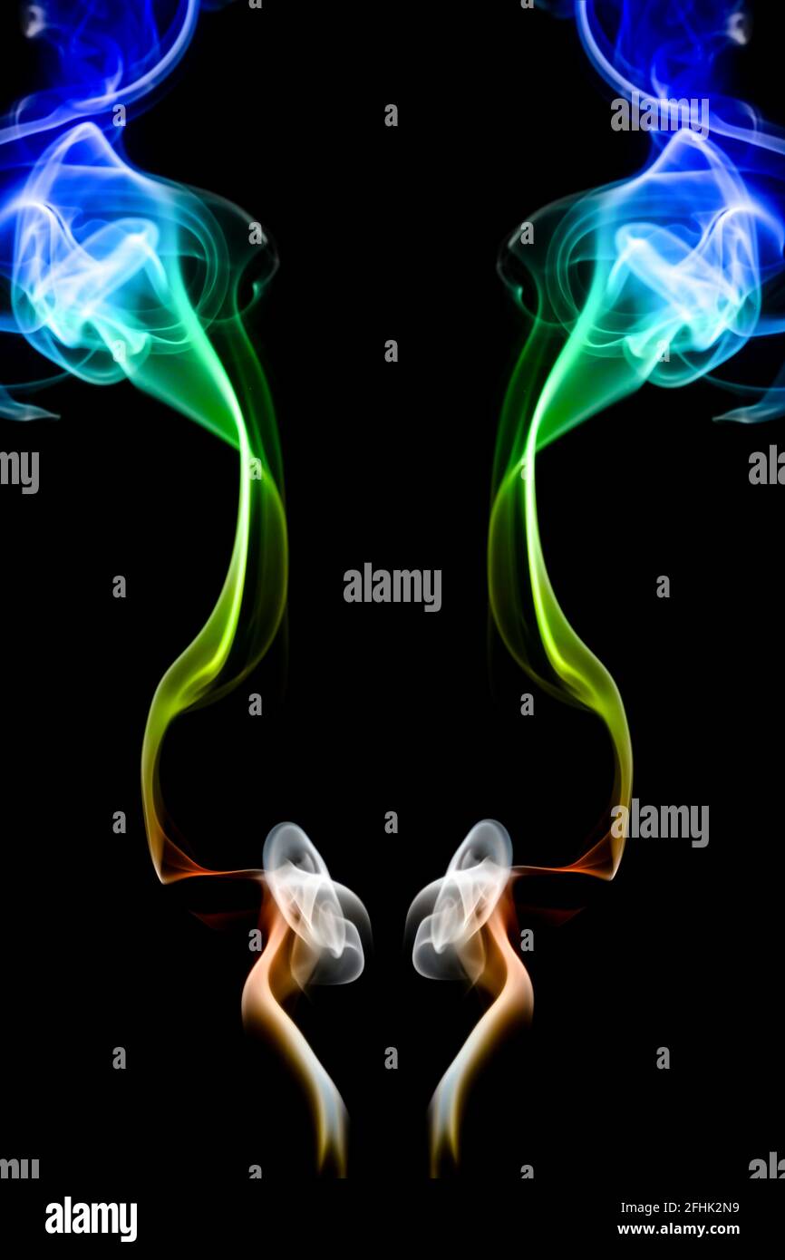 multicolored smoke of green and blue colors on a black isolated ...
