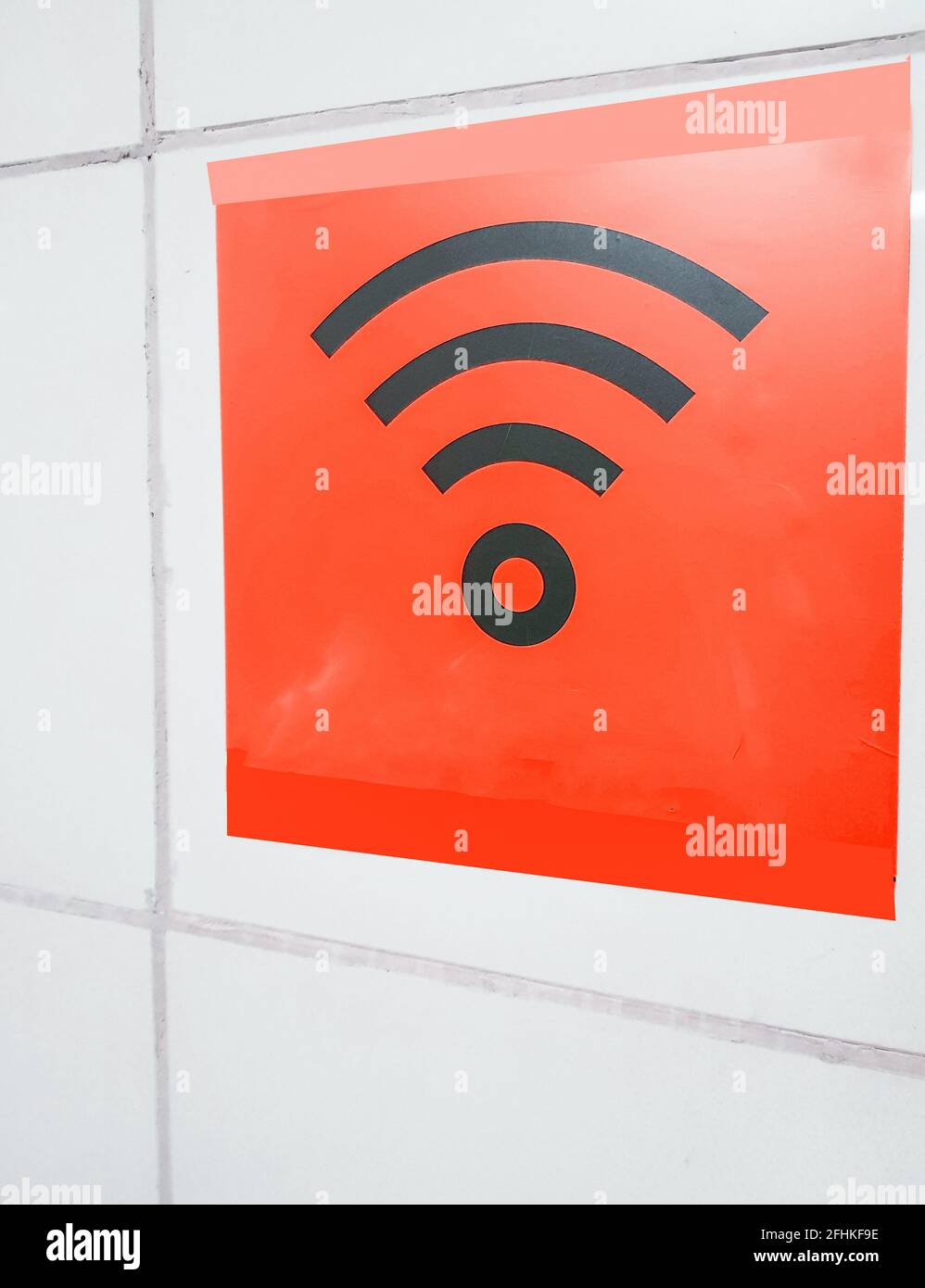 Free Wi-Fi is available in a public area, a sign on the white wall of a ...