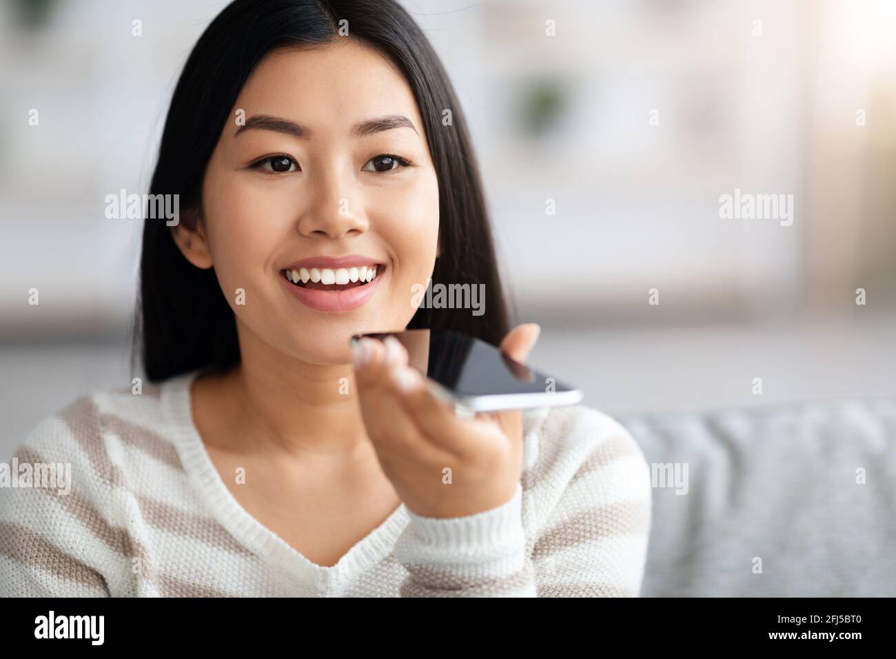 Happy Asian Lady Using Virtual Voice Assistant On Smartphone At Home ...