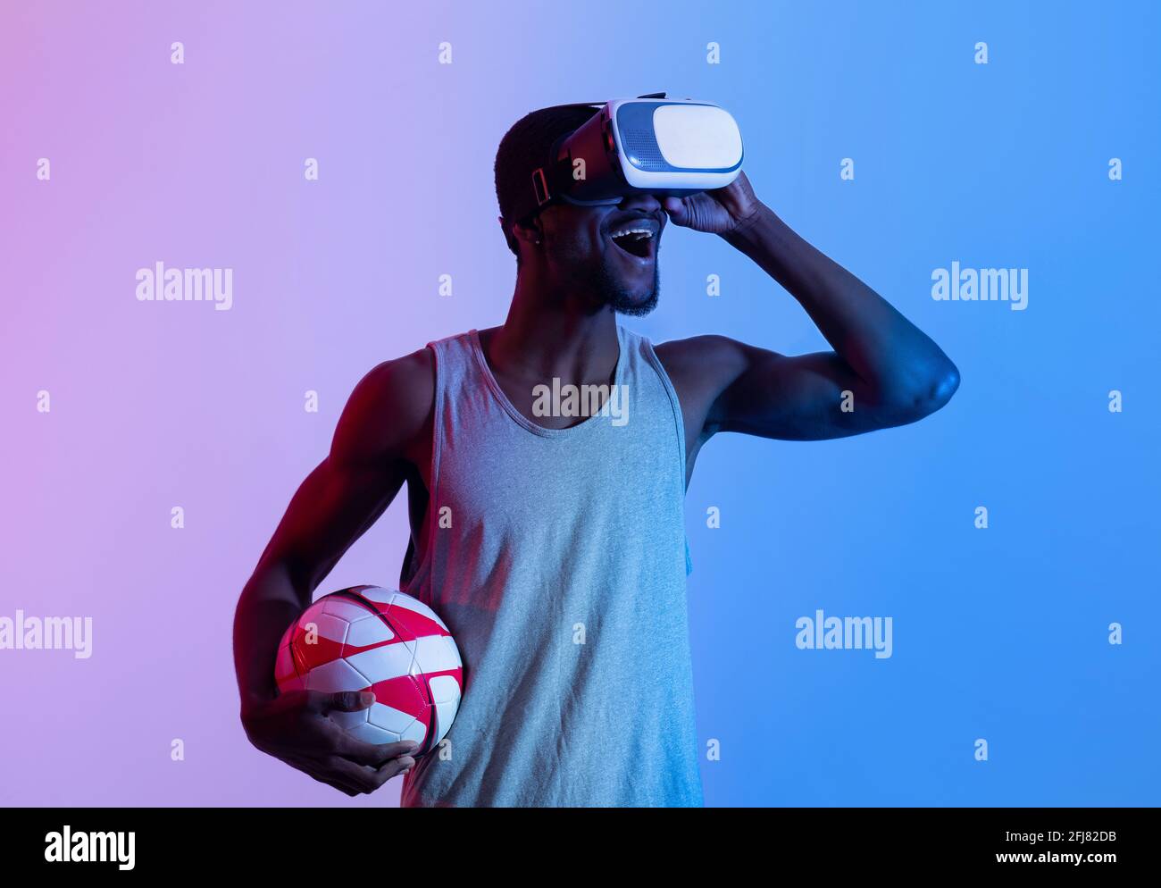 Exercising with virtual reality. Excited young black guy in VR headset ...