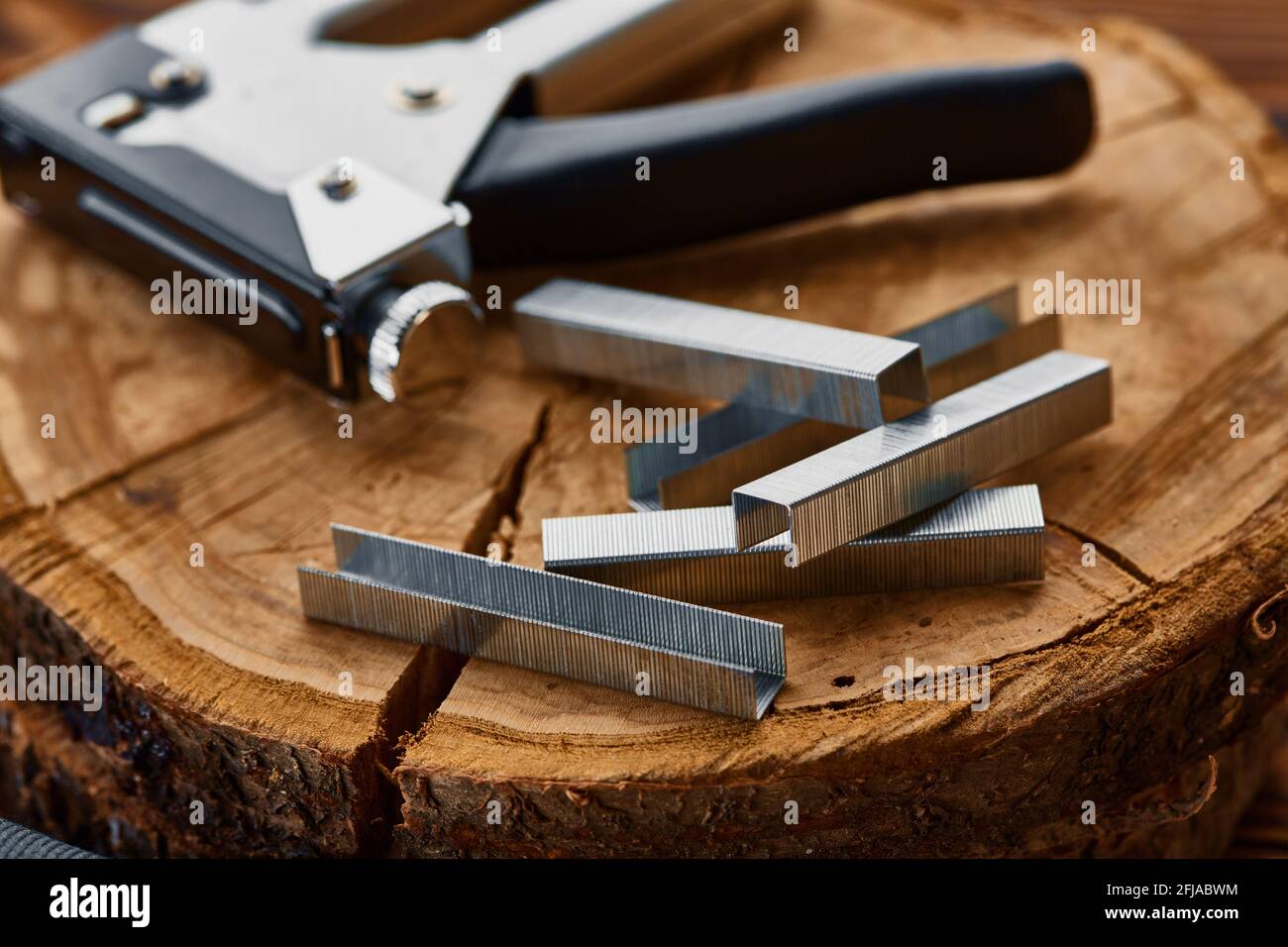 Metal stapler and steel staples on stump, macro Stock Photo - Alamy
