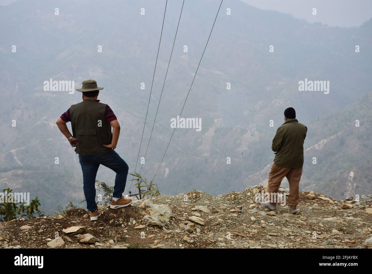 Two man standing on hilltop viewing the valley down Stock Photo - Alamy