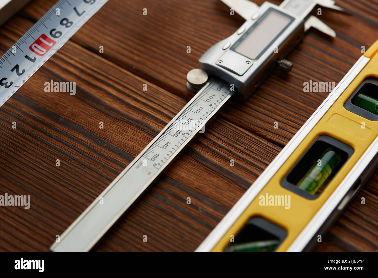 Level and caliper, macro view, wooden background Stock Photo - Alamy