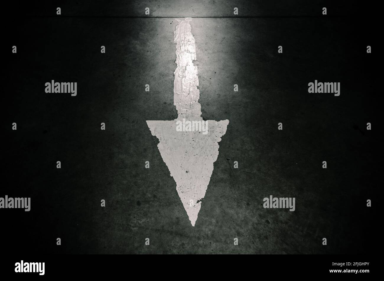 White arrow parking sign. Dark background Stock Photo - Alamy