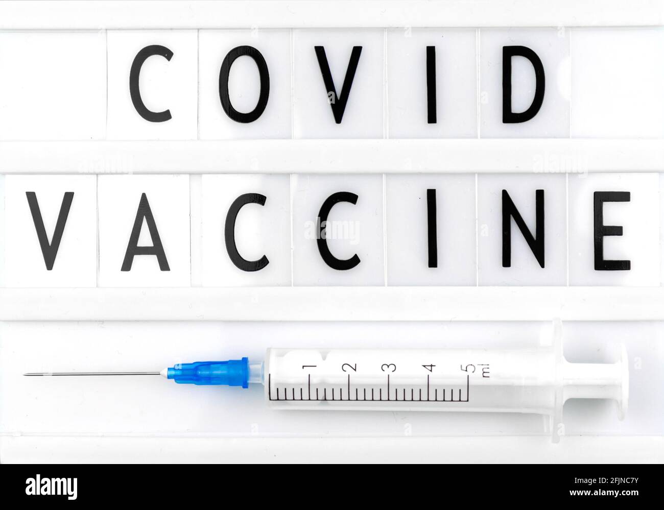 Covid vaccine sign with medical syringe on the lightbox with lettering ...