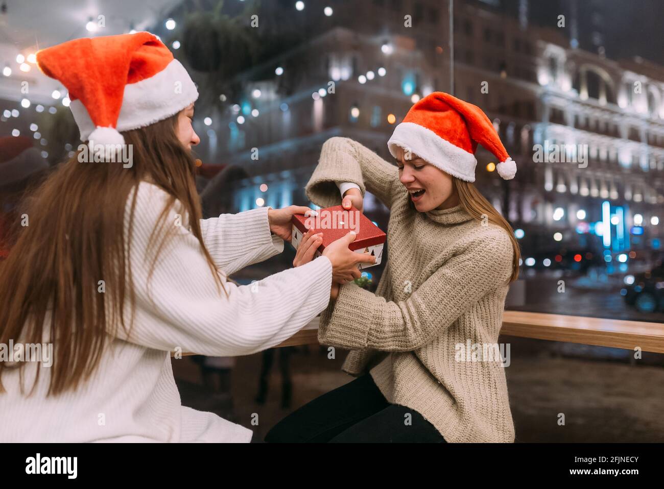 Girls fight for a gift at cafe. Friends fun in cafe Stock Photo - Alamy